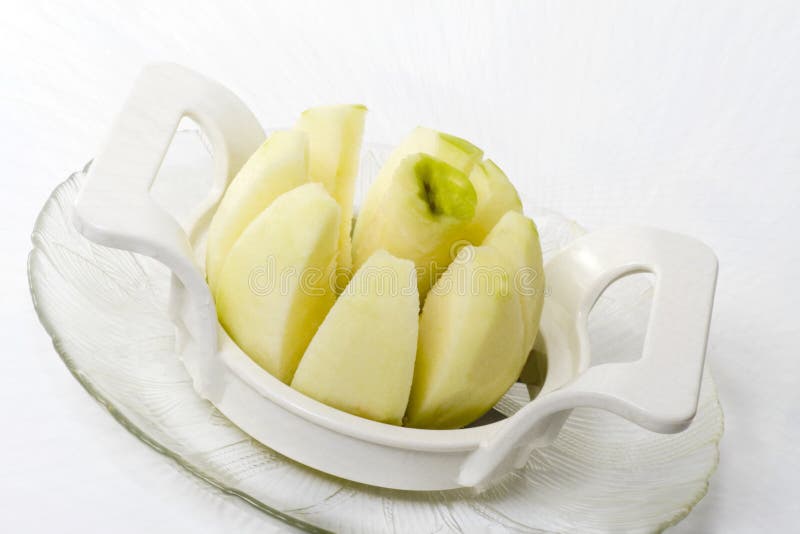 Peeled Green Apple in an Apple Slicer Stock Photo - Image of plate ...