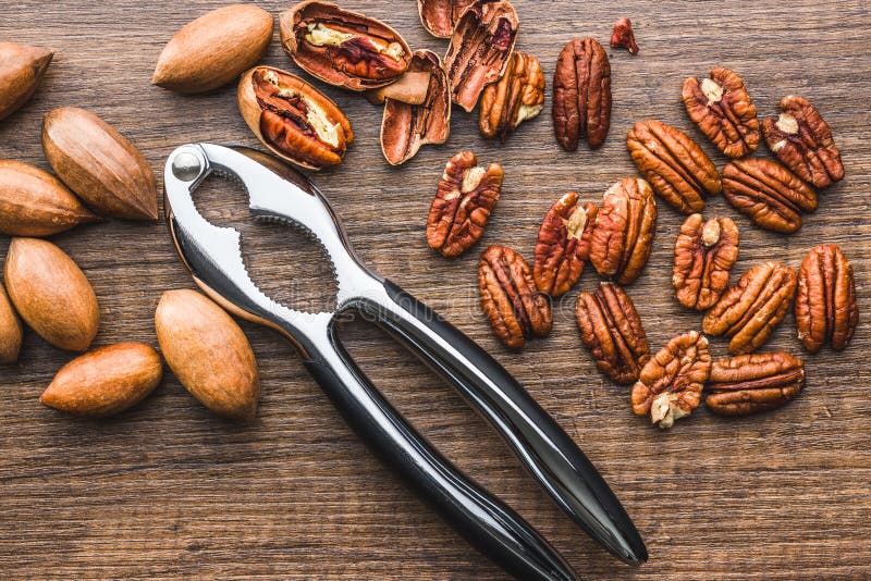 Peeled Pecan Nuts and Nutcracker on Wooden Table. Top View Stock Photo ...
