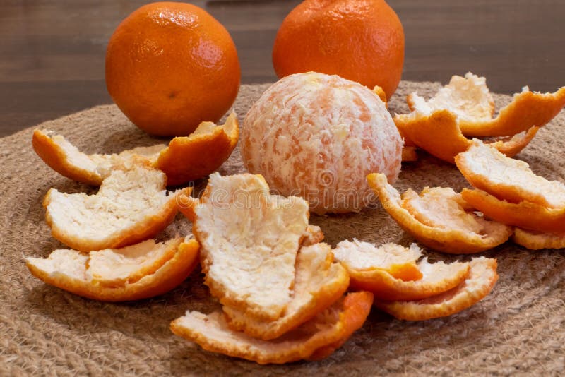 Peeled Ripe Tangerine in Peel Close-up on Dining Table Stock Photo ...