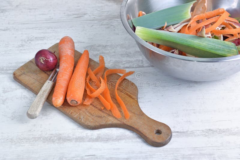 Peeling Carrots on a Cooking Plank and Bowl Full of Waste on a Table ...