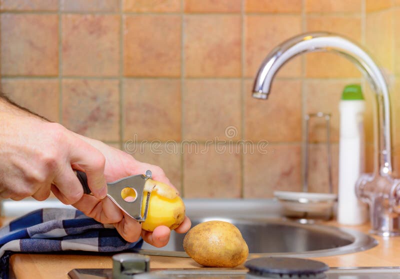 Peeling a Potato with Peeler in a Kitchen Stock Photo - Image of fresh ...