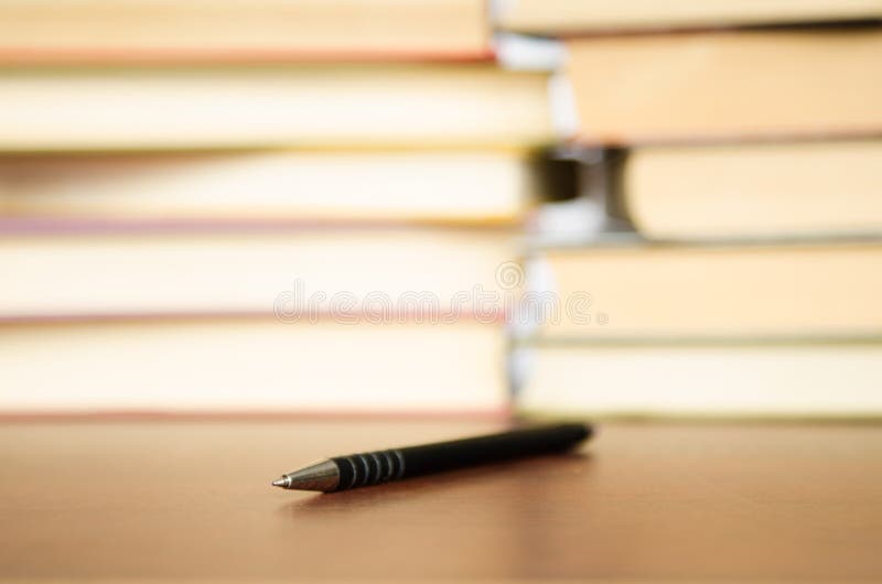 Pen on Background of a Stack of Colorful Books Stock Image - Image of ...