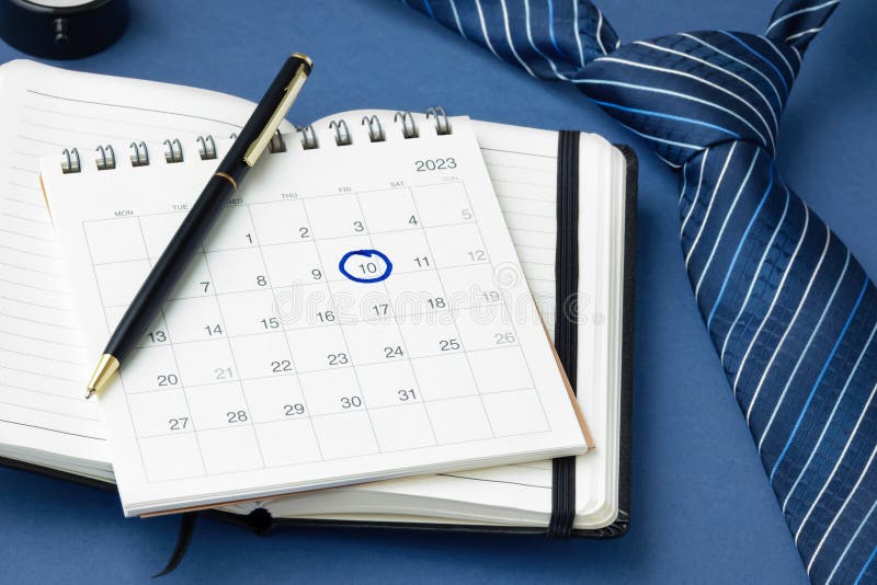 Pen on Calendar with Marked Date and Tie on Blue Background Stock Image ...