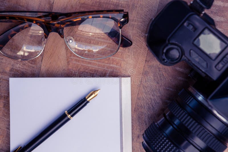 Pen on Paper by Camera and Eye Glasses at Table Stock Image - Image of ...