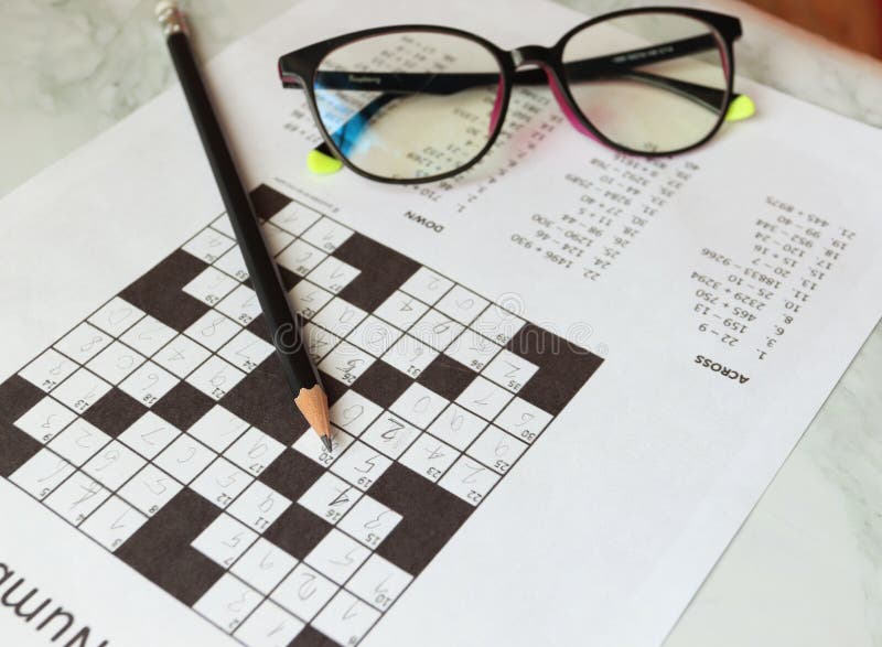 Pencil and Glasses on the Paper with Solved Crossword Puzzle Stock ...