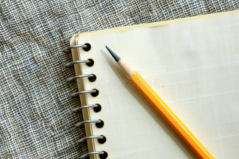 Pencil Resting in the Spiral of a Notepad with Blank Sheets on a Fabric ...