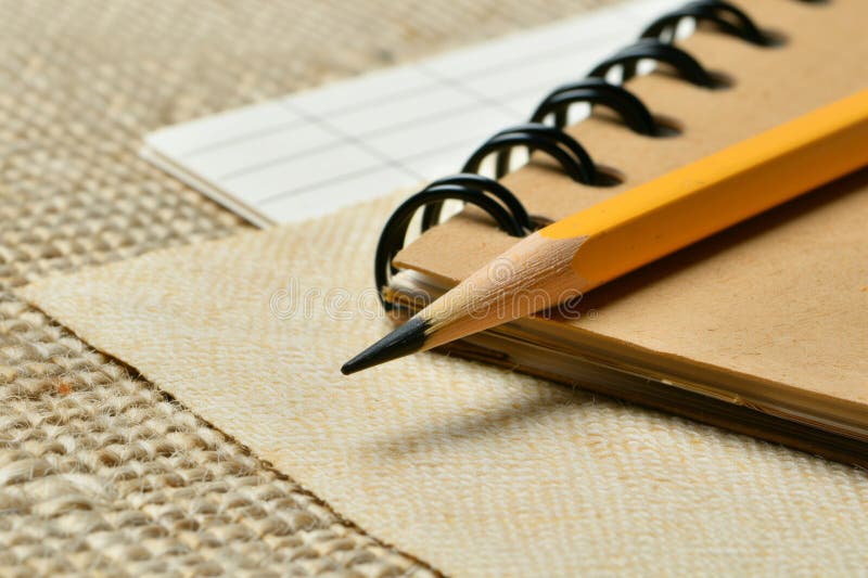 Pencil Resting in the Spiral of a Notepad with Blank Sheets on a Fabric ...