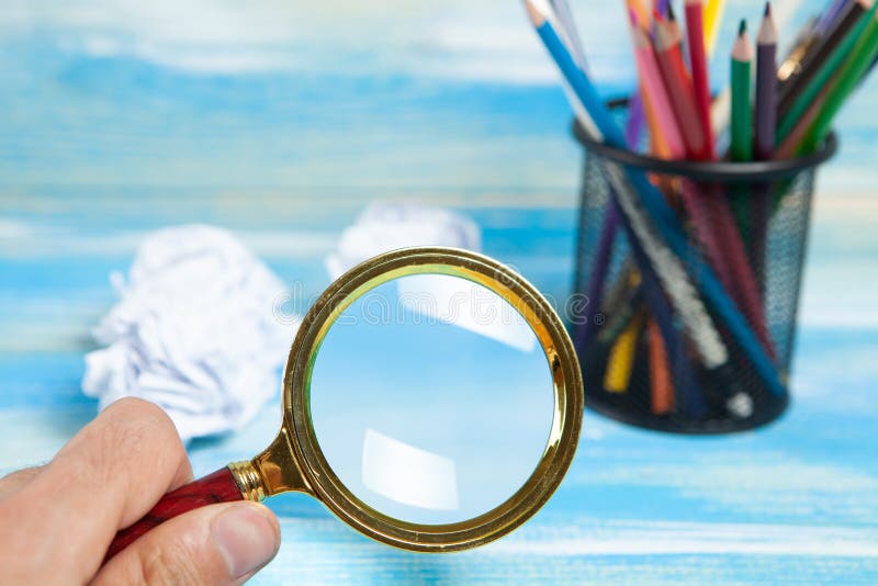 Pencils in a Stand, a Magnifying Glass and Crumpled Papers . Concept ...