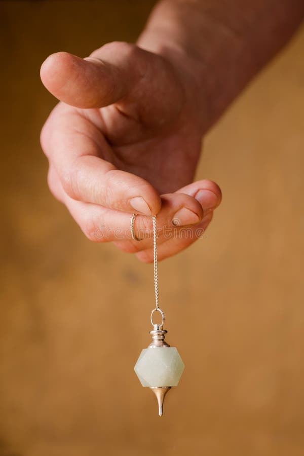 The pendulum in the hand stock photo. Image of hand - 182472860