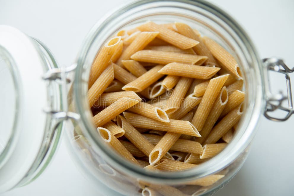 Penne pasta in glass jar stock photo. Image of uncooked - 84725056