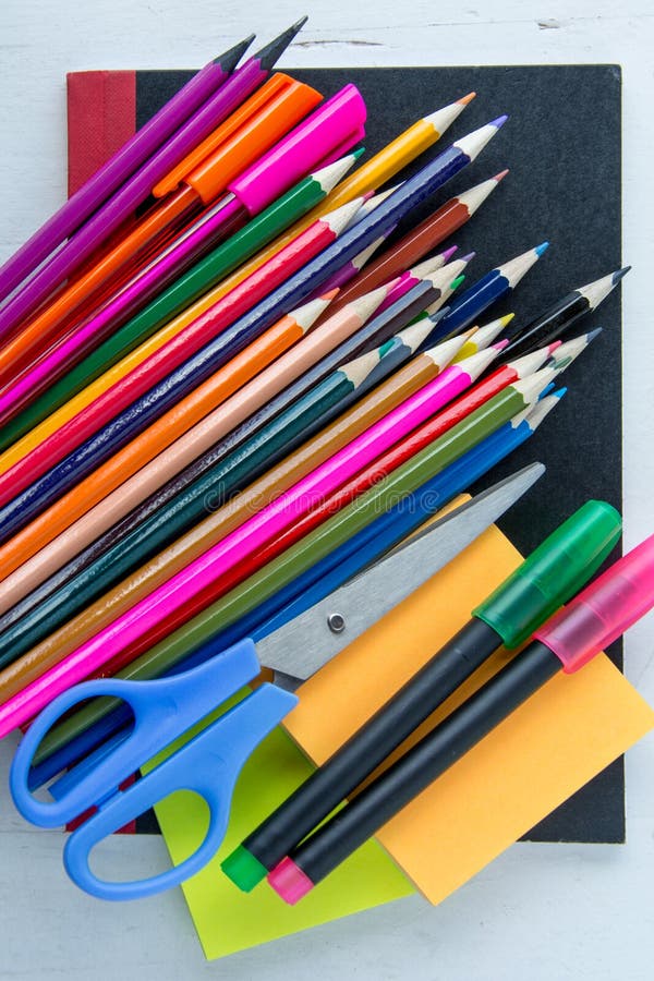 Pens, Pencils, Scissors and Post it Notes on Black Note Book Stock ...