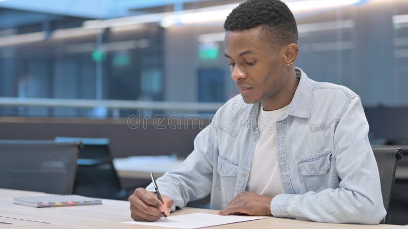 Pensive African Man Writing on Paper, Thinking Stock Photo - Image of ...