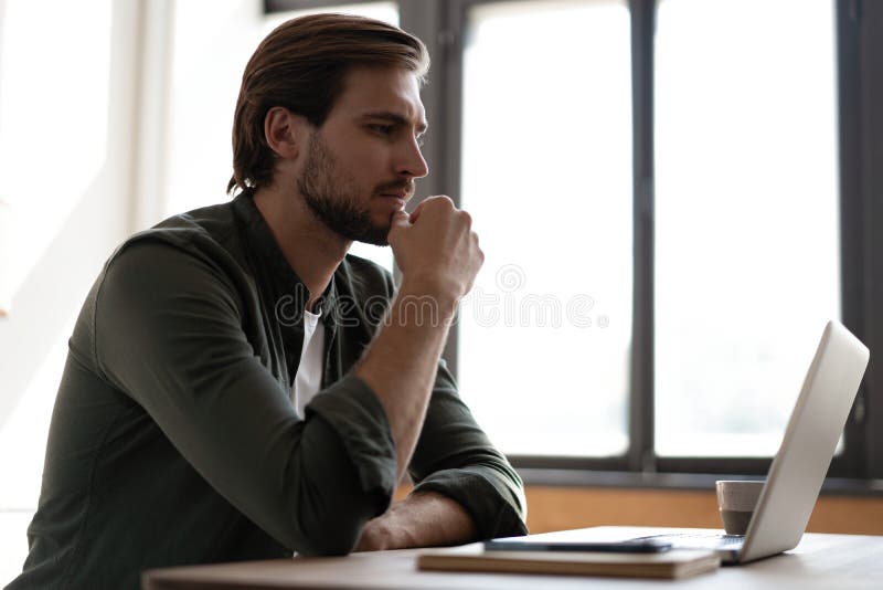 Pensive Bearded Man Sitting at Table Work at Laptop Thinking of Problem ...