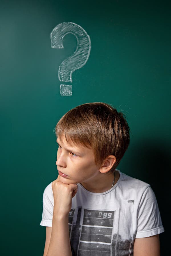 Pensive Boy on the Background of a Green Board. a Question Mark is ...