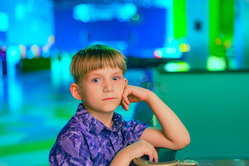 A Pensive Boy Stands Near the Pool Table, Supporting His Head with His ...