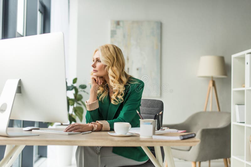 Pensive Businesswoman Looking Away while Using Desktop Computer Stock ...