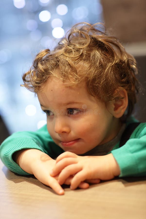 Pensive child at table stock image. Image of cute, lips - 36985353