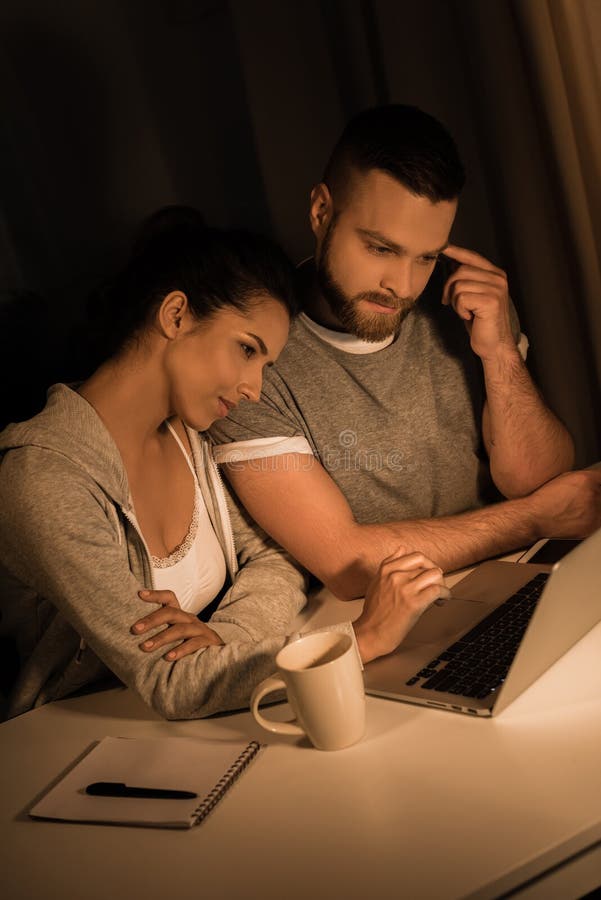 Pensive Couple Looking at Laptop while Sprnding Time at Home Stock ...