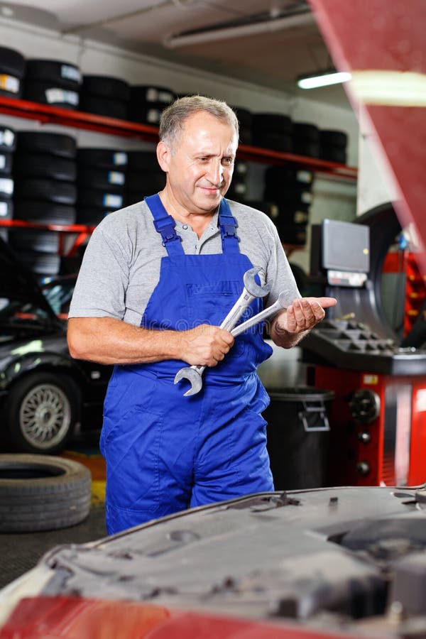Pensive Elderly Man Mechanic Looking at Car in Auto Workshop ...