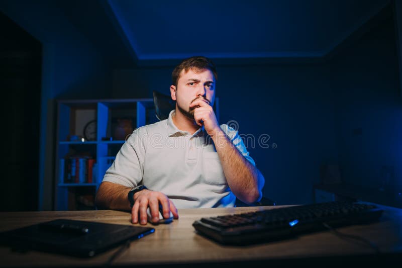 Pensive Freelancer Man Sitting at Home at the Computer at Night and ...
