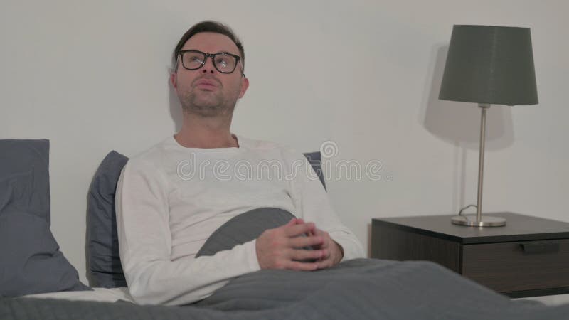 Pensive Casual Man Thinking while Sitting in Bed Stock Photo - Image of ...