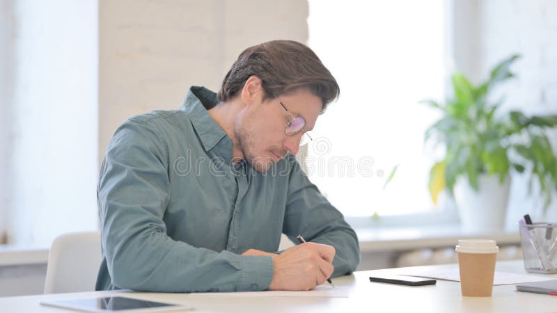 Pensive Middle Aged Man Writing on Paper, Thinking Stock Photo - Image ...