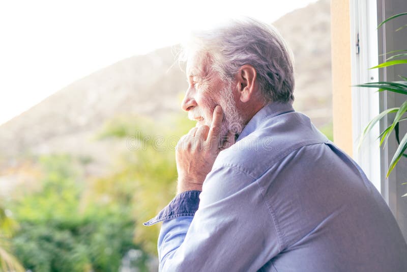 Pensive Old Man at the Window Looking Away. Smiling Caucasian White ... Pensive Old Man at the Window Looking Away. Smiling Caucasian White ...