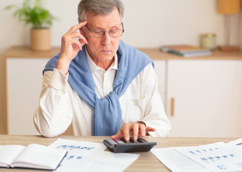 Pensive Senior Man Using Calculator Sitting in Modern Office Stock ...