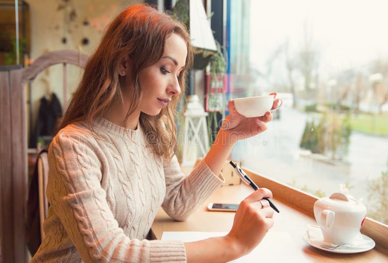 Pensive Student Studying and Learning Taking Notes Drinking Tea in a ...