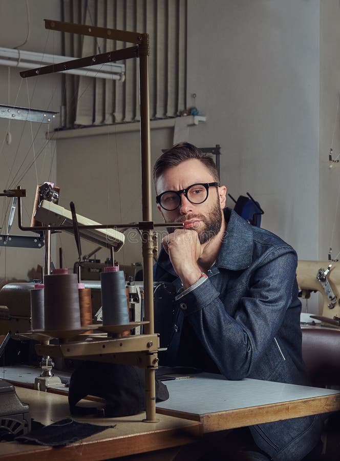 Tailor Sitting at Table with Sewing Machine and Looking at a Camera in ...