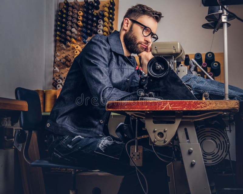 Pensive Tailor Sitting at a Table with Hand on Chin in a Sewing ...