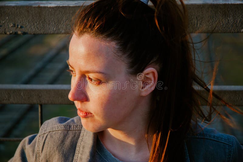 Pensive Woman on Bridge at Sunset for Reflective Mood Themes Stock ...