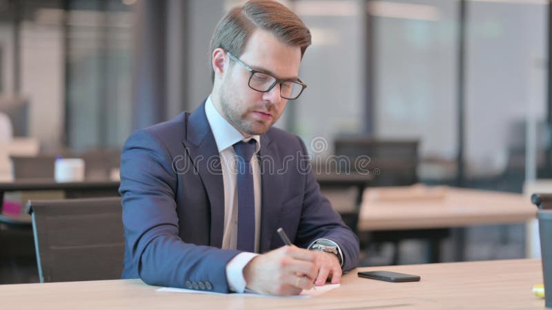 Pensive Young Businessman Writing on Paper, Thinking Stock Image ...