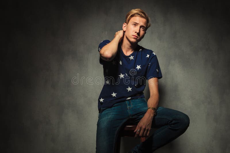 Pensive Young Casual Man Sitting and Looking Away Stock Photo - Image ...