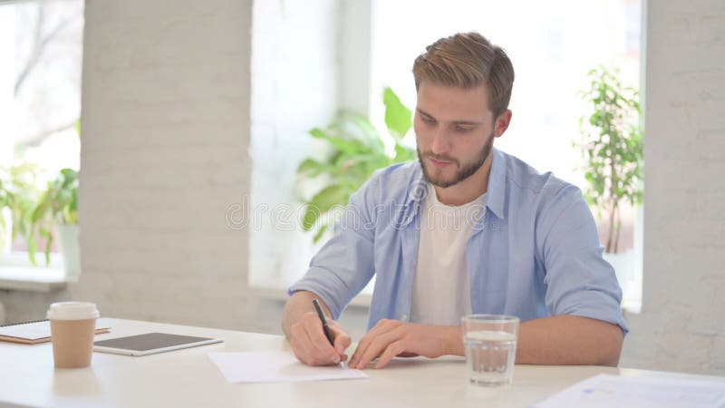 Pensive Young Man Writing on Paper, Thinking Stock Photo - Image of ...
