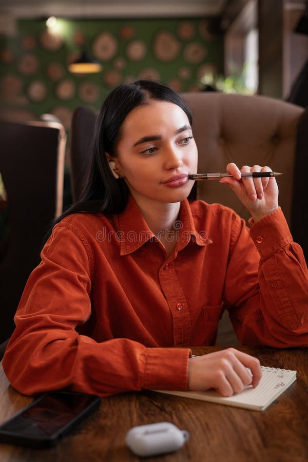 Pensive Young Female Writer with Notepad and Pen Looking Away and ...