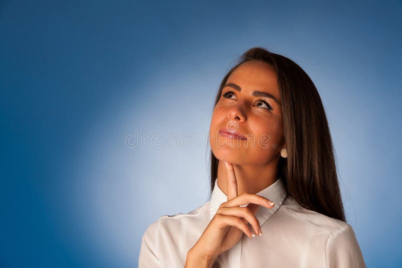Pensive Young Hispanic Woman Thinking in Front of Blue Background Stock ...