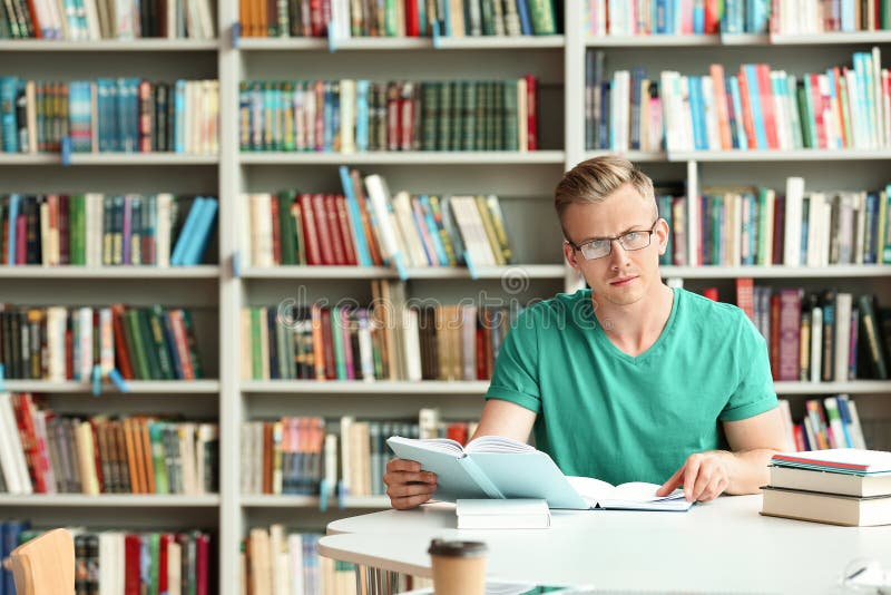 Pensive Young Man with Books at Table in Library Stock Image - Image of ...