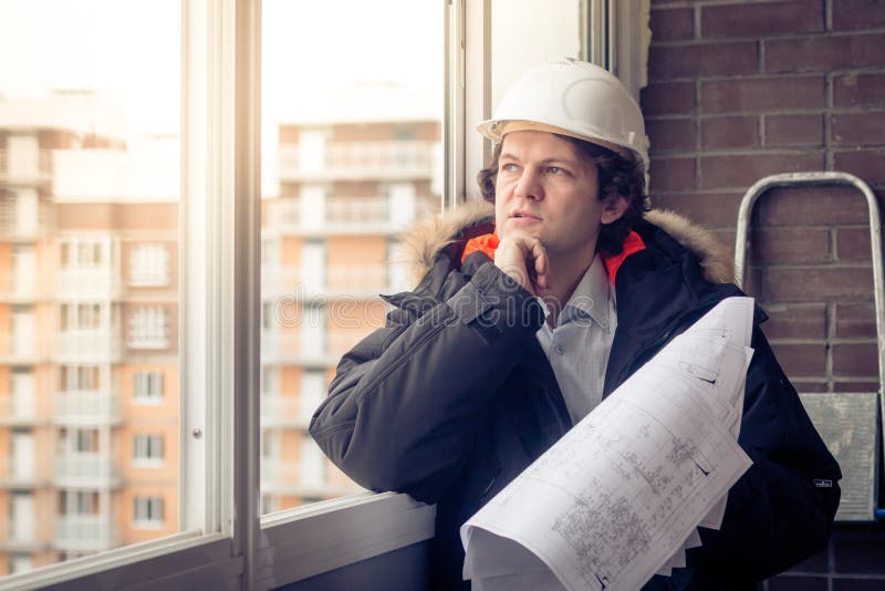 Pensive Young Man Builder in Hard Hat Standng and Thinking. Soft Focus ...