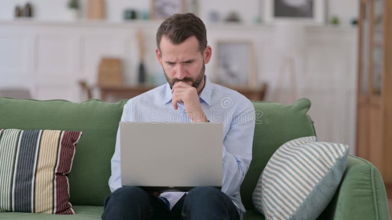 Pensive Young Man with Laptop Thinking on Sofa Stock Image - Image of ...
