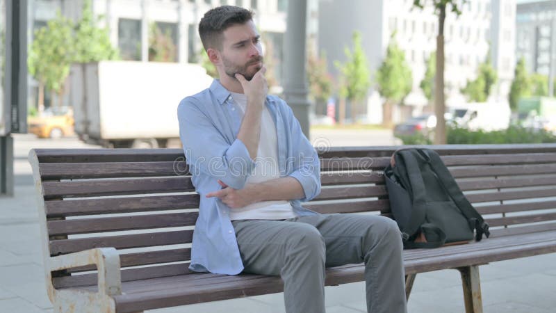 Pensive Young Man Thinking while Sitting on Bench Stock Video - Video ...