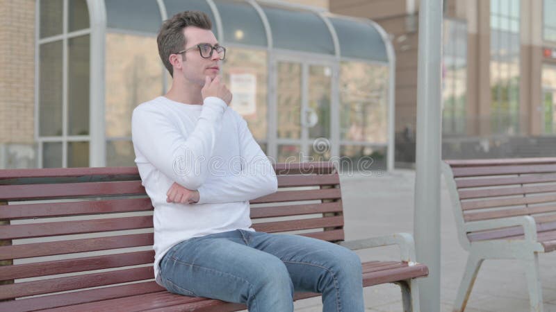 Pensive Young Man Thinking while Sitting Outdoor on Bench Stock Image ...
