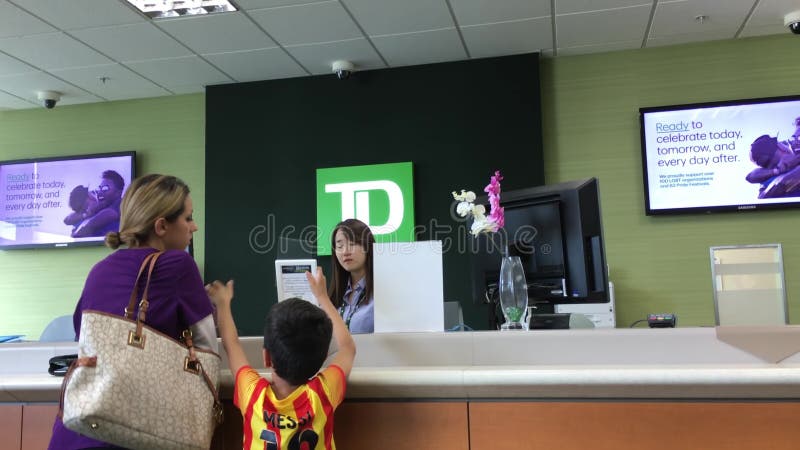 People at a Bank Counter Talking To the Teller Inside TD Bank Stock ...