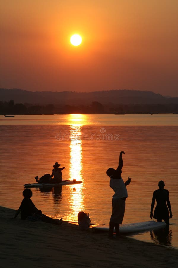 People on beach at sunset stock photo. Image of water - 4983074