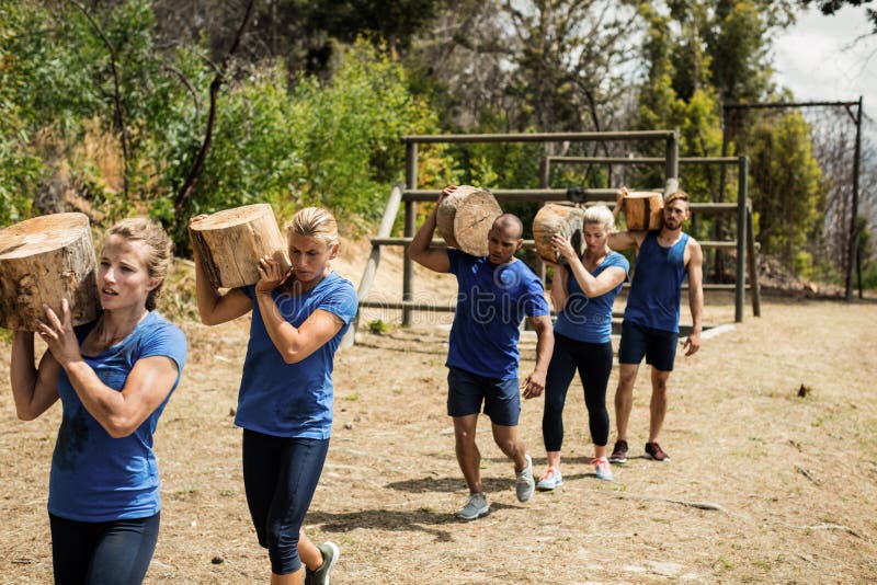 People Carrying Heavy Wooden Logs during Obstacle Course Stock Photo ...