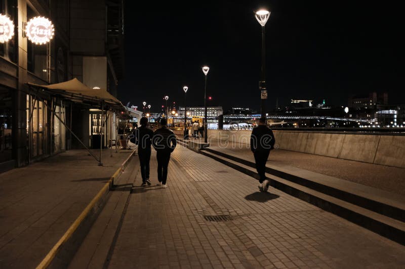 Cobblestone Walkway Along a Waterfront, Illuminated by Streetlights ...