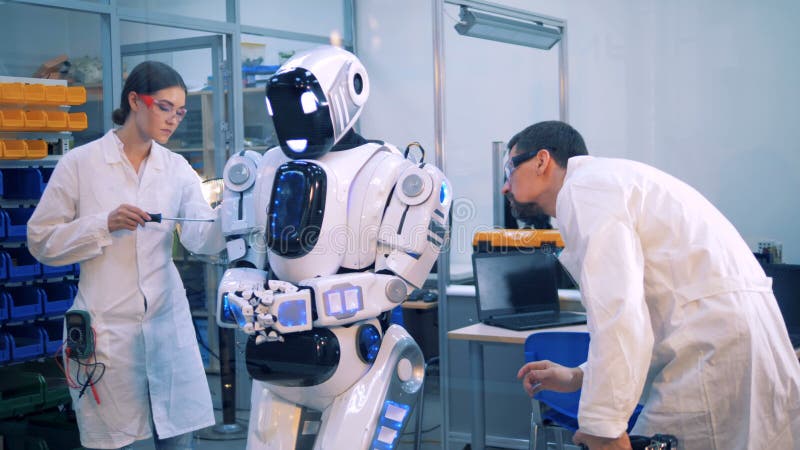 Young Woman is Coming To a Human-like Robot, they are Hugging and ...