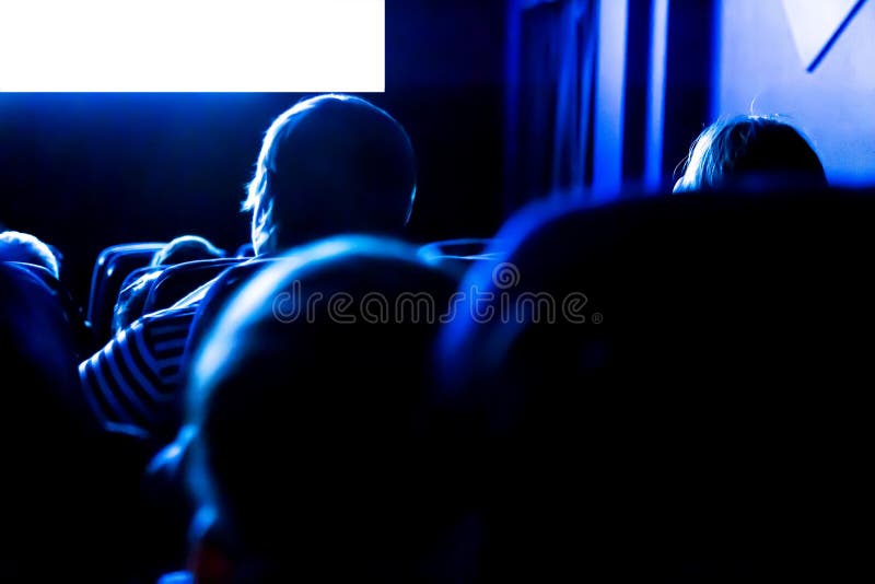 People in the Cinema Watching a Movie. Blank Empty White Screen Stock ...