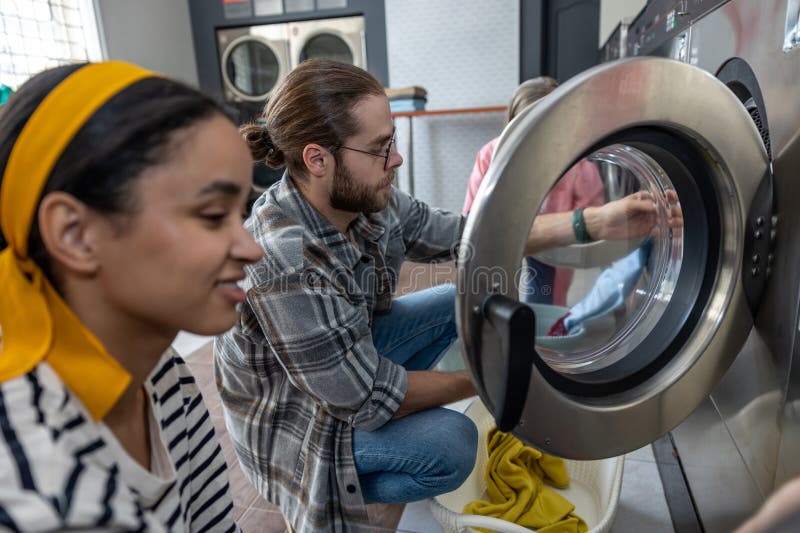 People Completing Their Housework Chores Using Washing Machines Stock ...