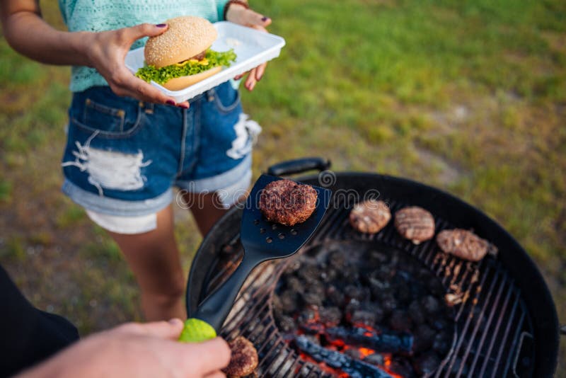 People Cooking Meet on Barbeque Grill and Making Hamburger Outdoors ...